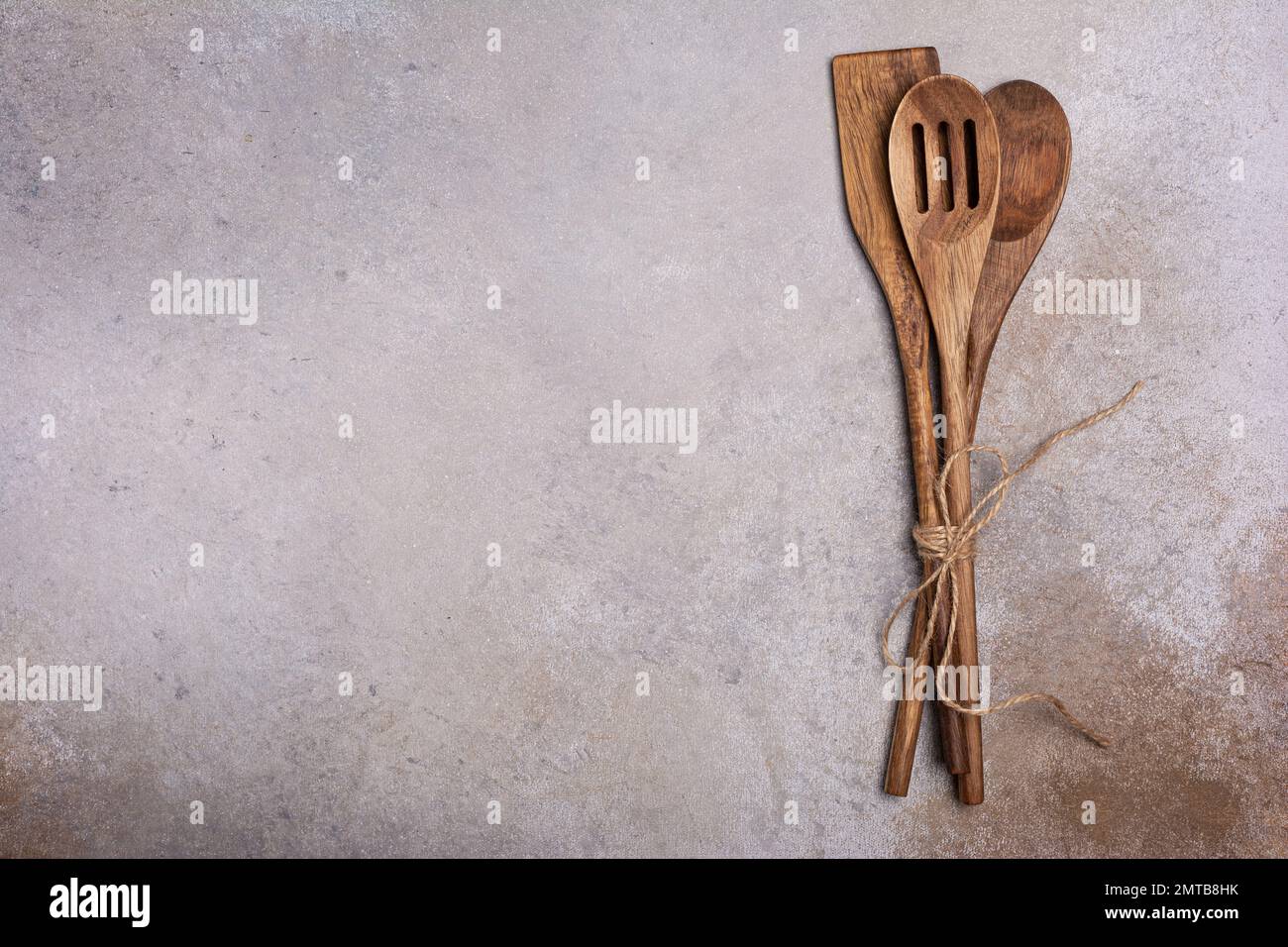 Utensils cutlery. Top view of rustic wooden scapula and spoons on grey ...