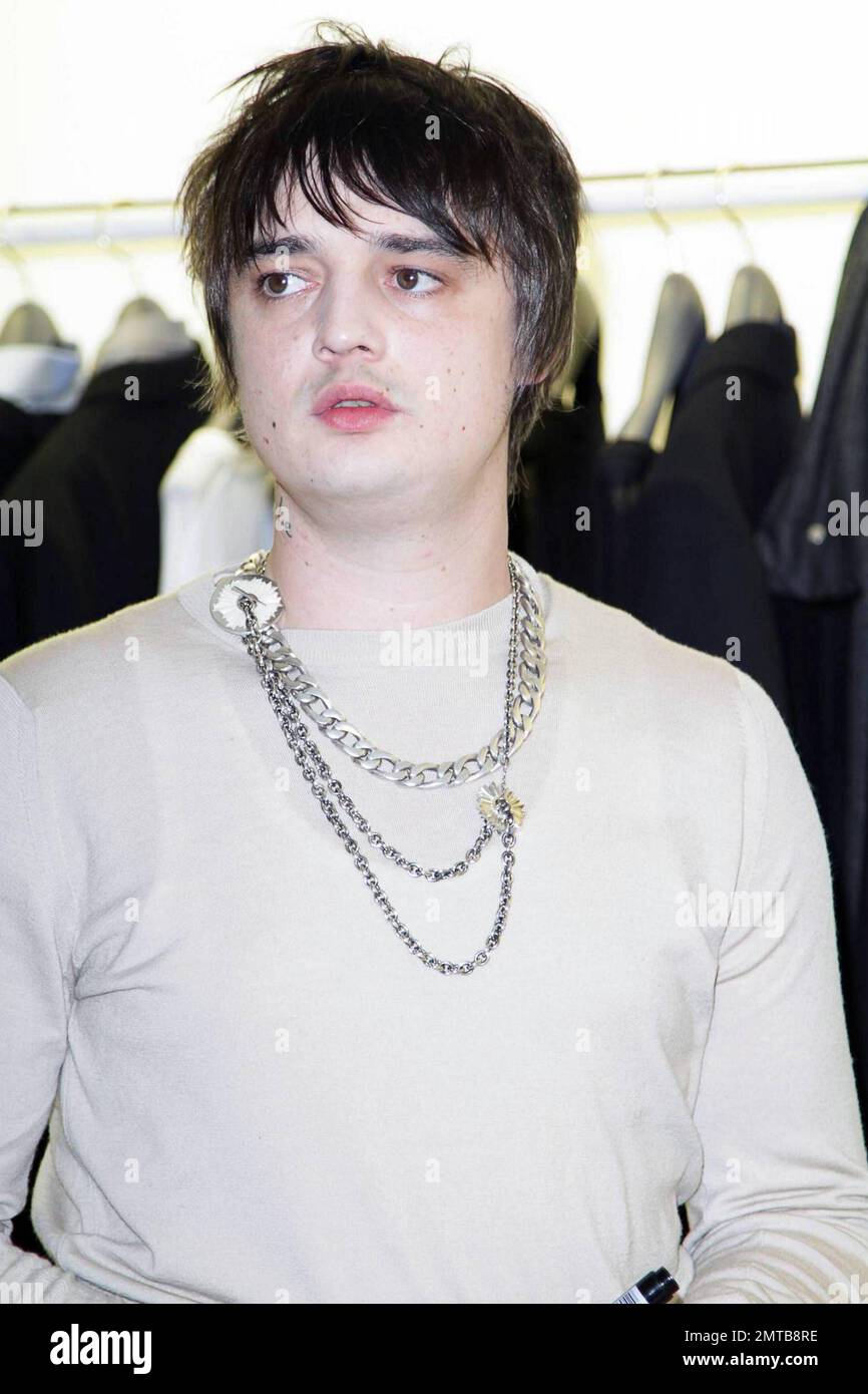 Wearing a tight-fitting tan sweater and black pants, British rocker ...