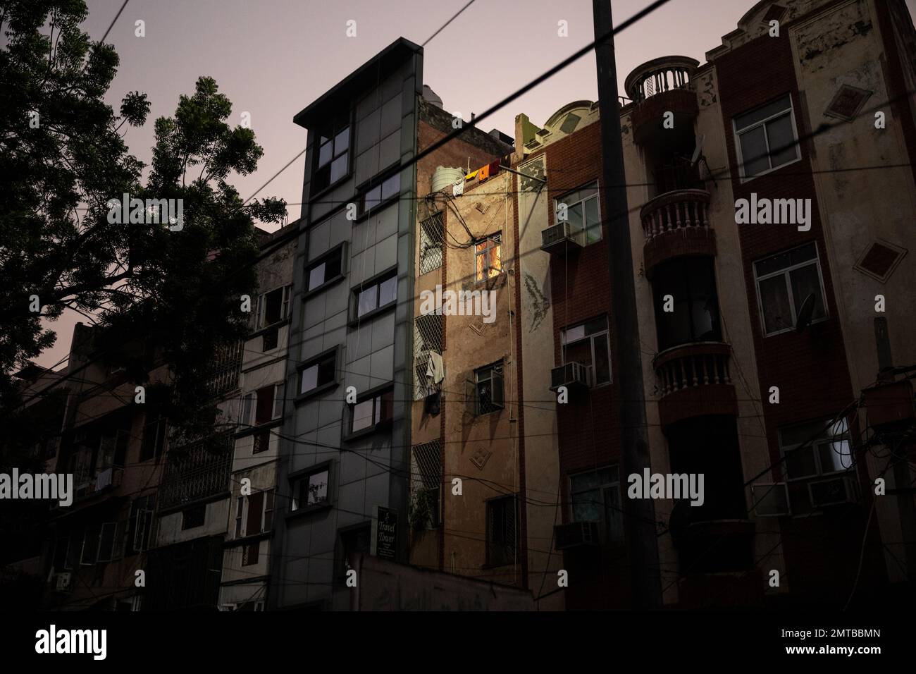 A single room's light is on in a block of apartments in Delhi, India ...