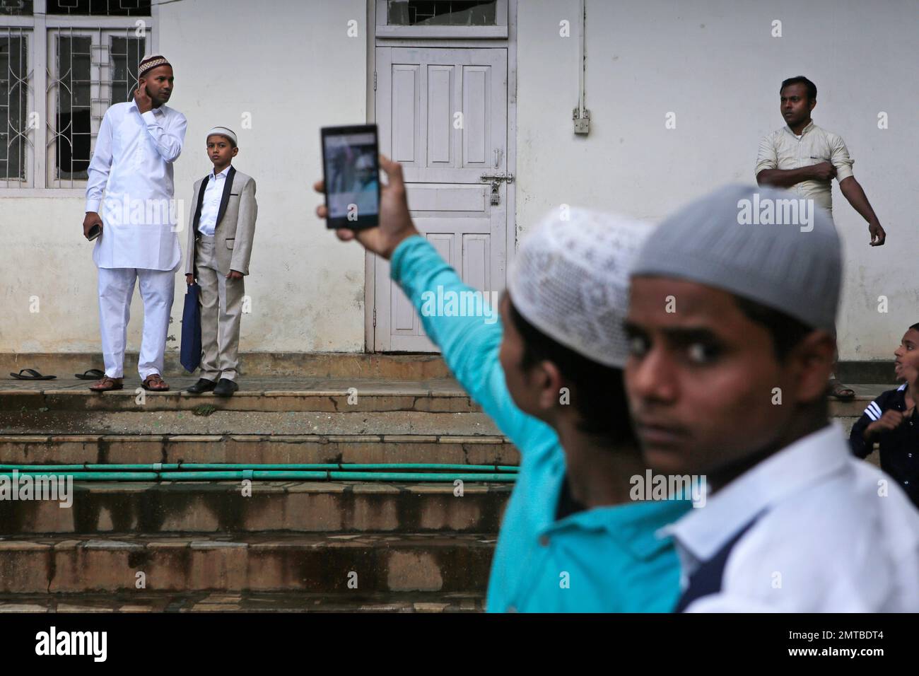 A Nepalese Muslim take photographs of his friends after offering Eid al ...