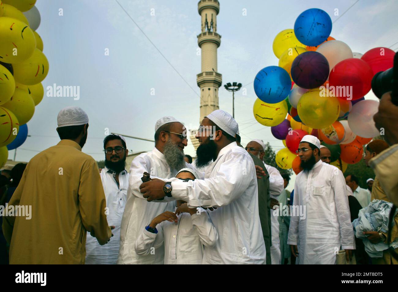 Pakistani Muslims greet each other after the Eid al-Fitr prayer that ...
