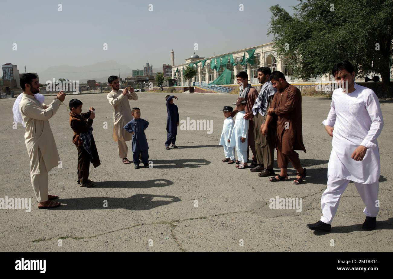 Men take pictures after Eid al-Fitr prayers in Eid Gah mosque in Kabul ...