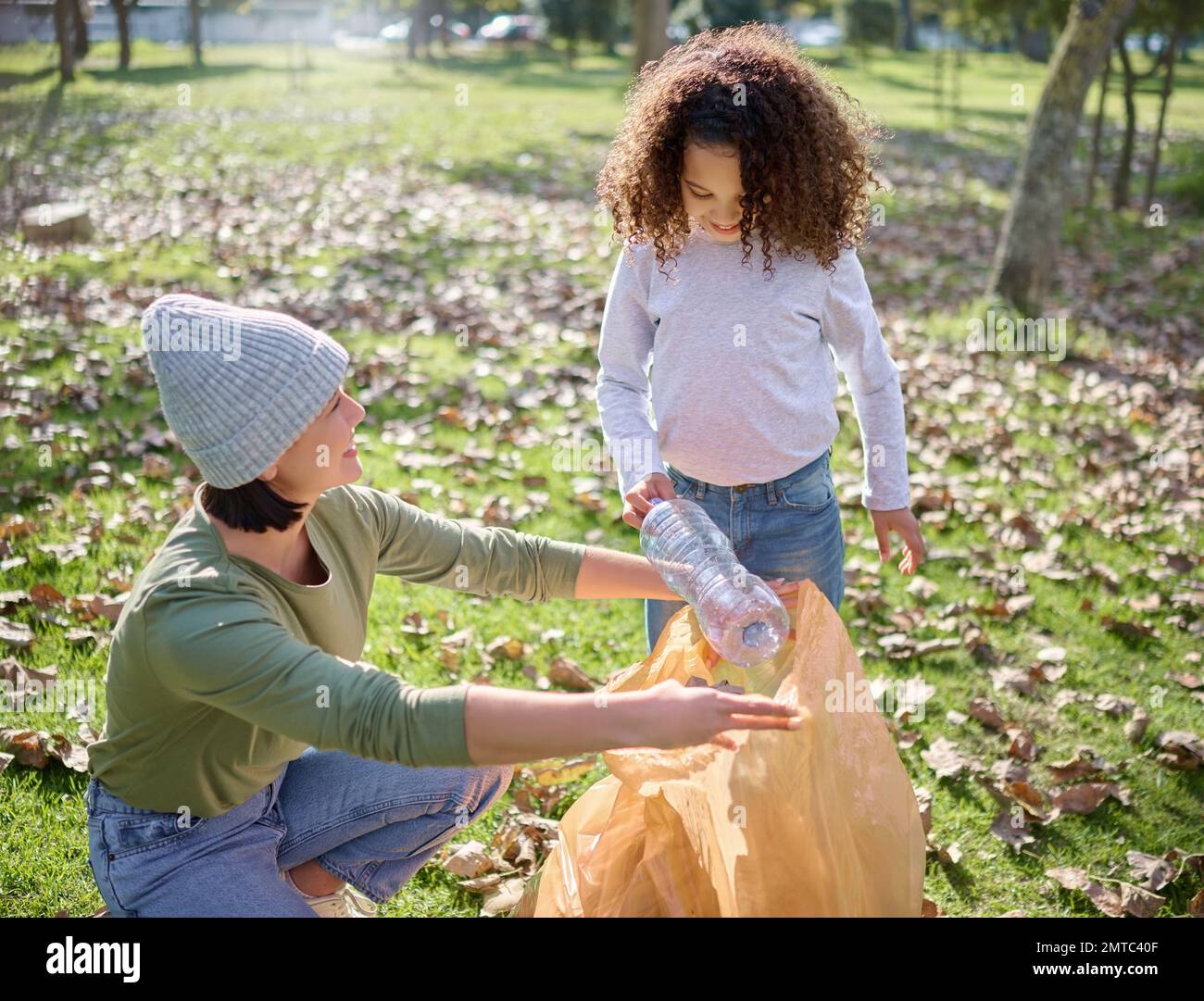 Trash, volunteer woman and child cleaning garbage, pollution or waste ...