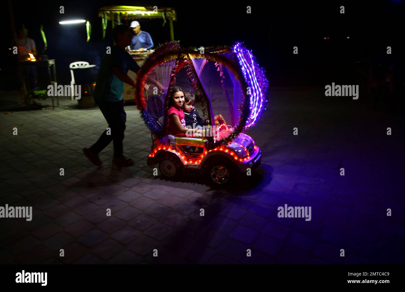 Children rides an electronic toy car while touring on the last Friday ...