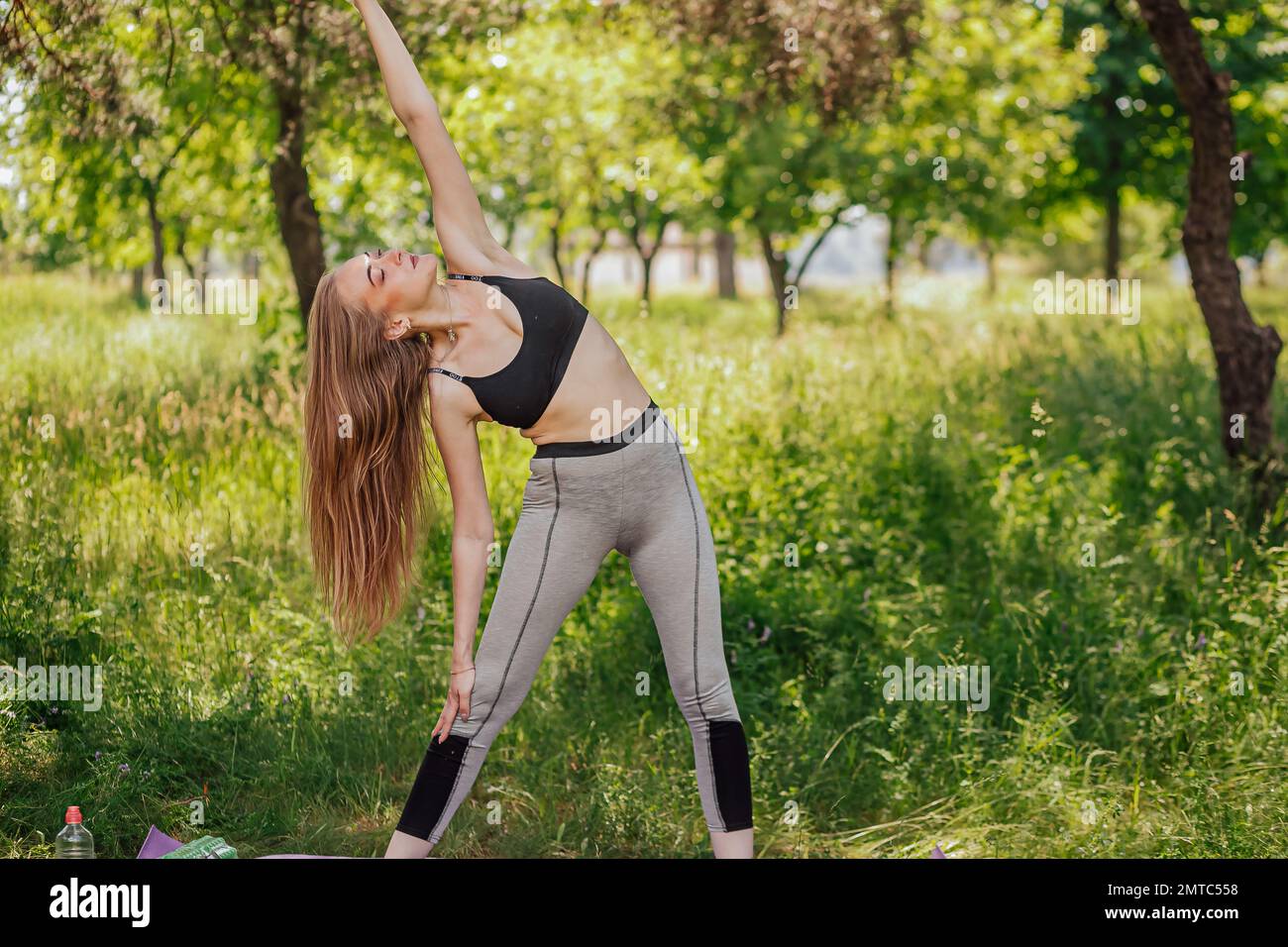 Yoga woman on green grass girl relaxes in the field. Yoga woman in ...