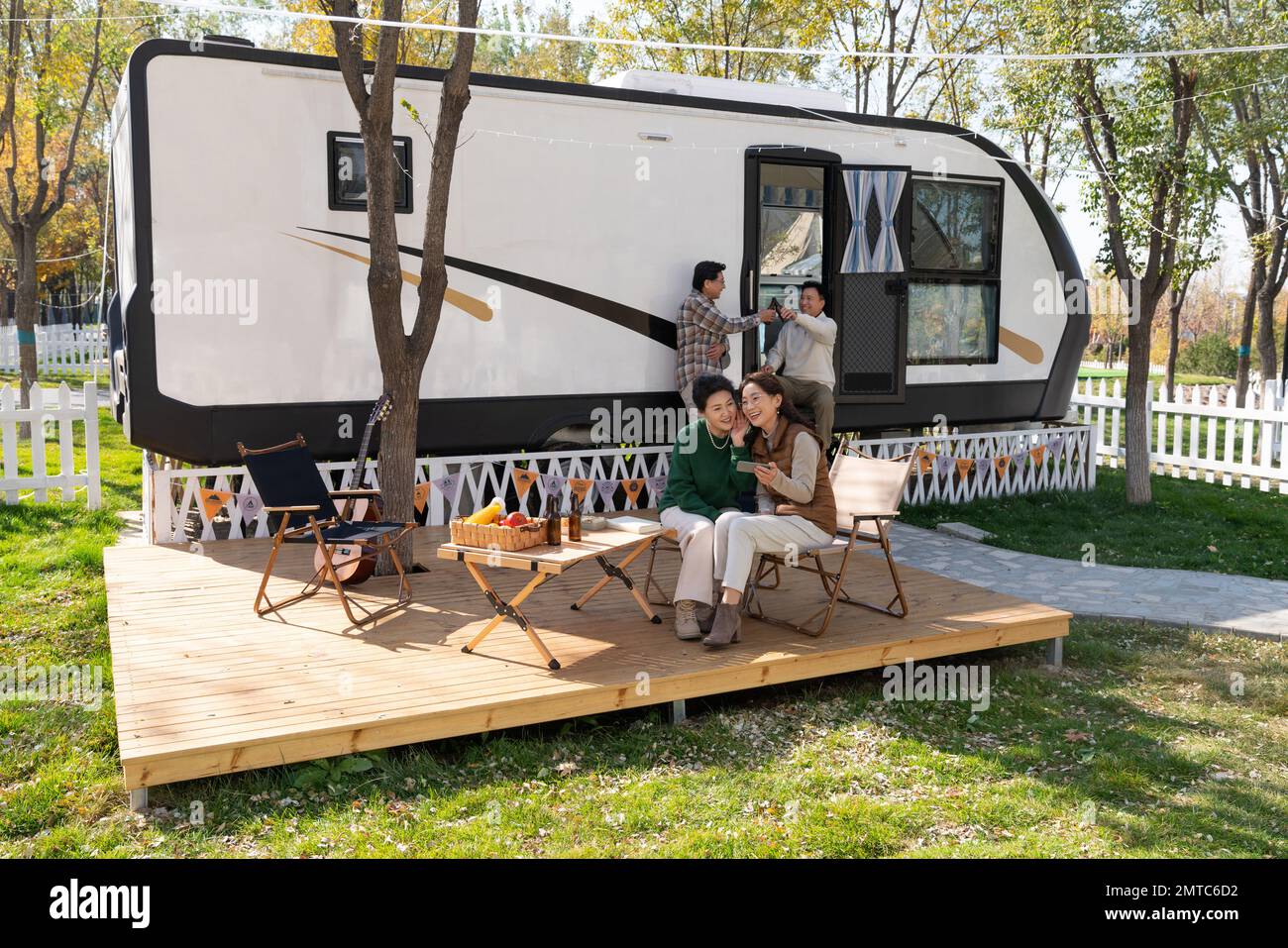 A group of old people sitting in the rv campsite beer watch video chat ...