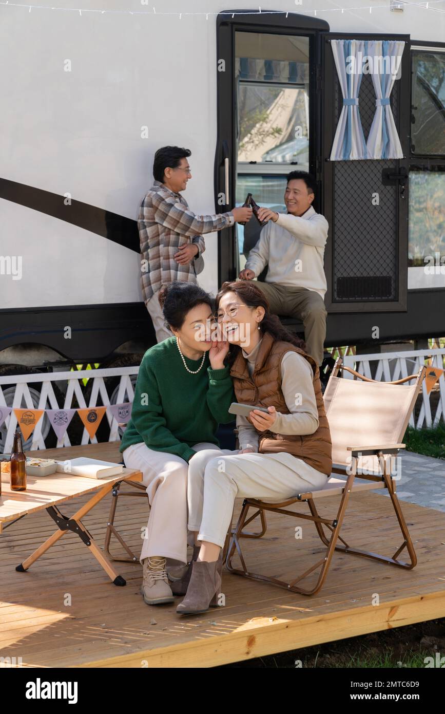 A group of old people sitting in the rv campsite beer watch video chat ...