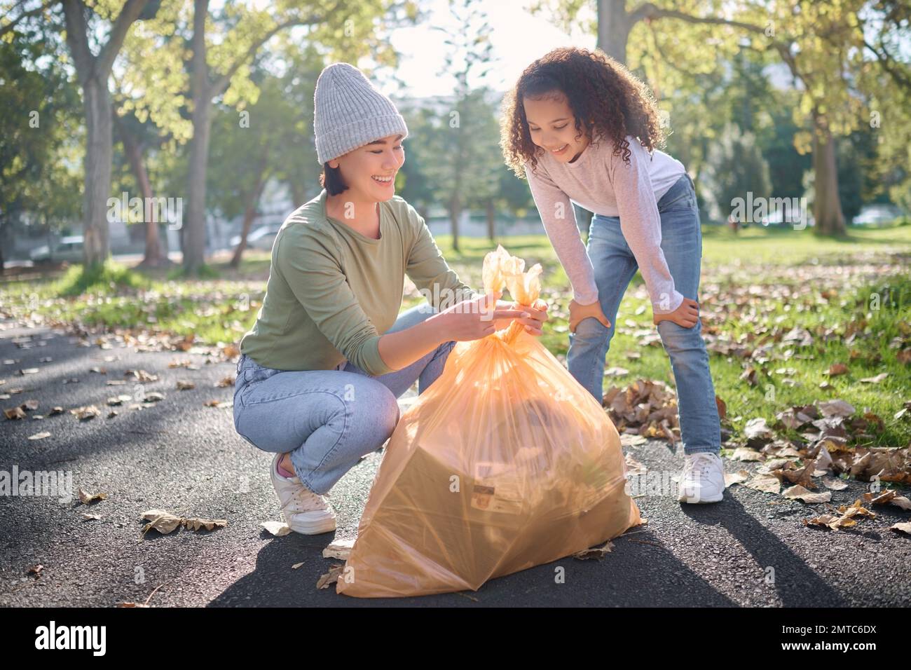 Trash, volunteer woman and kid cleaning garbage, pollution or waste ...