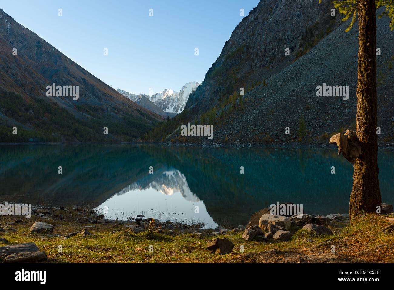 Outcrop of rock on the shore with snow and traces of rust from stones ...