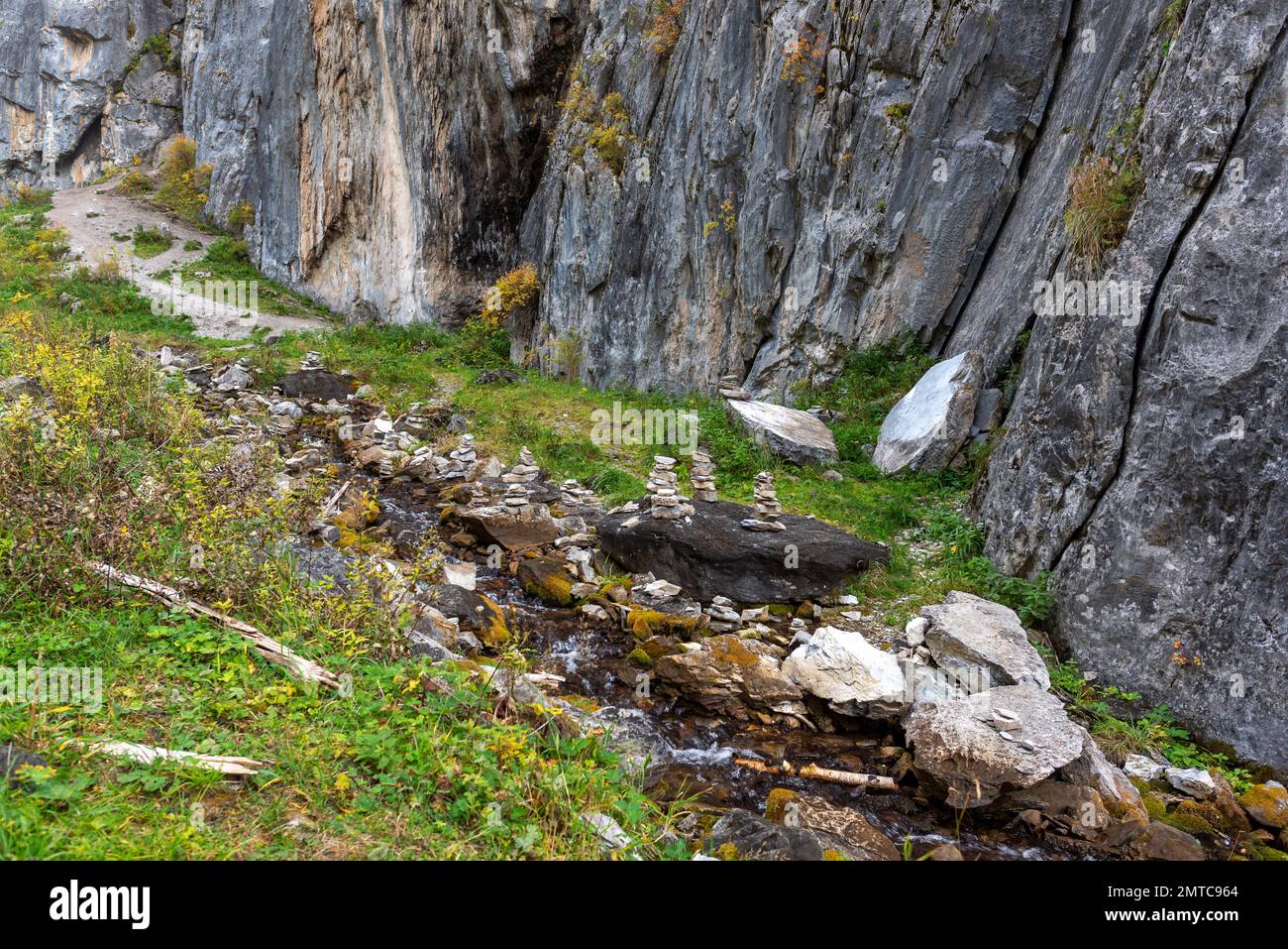 Stones piled on top of each other along the path goes to the stone wall ...