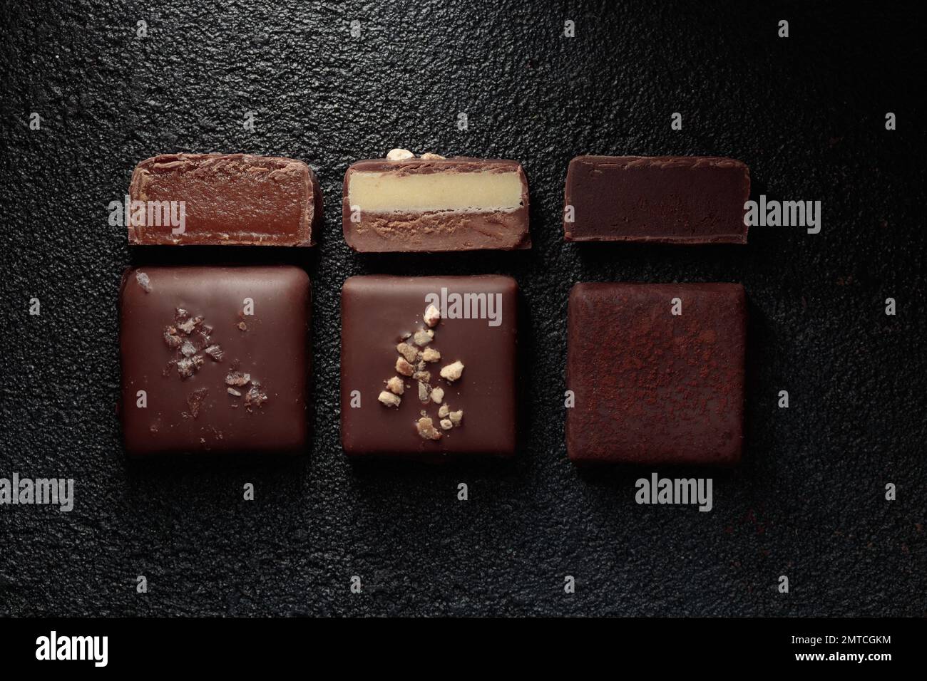Row of chocolate handcrafted bonbons and cutted pieces of candy with ...