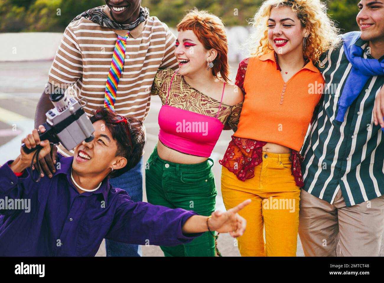 Young diverse people having fun with old vintage video camera outdoor ...