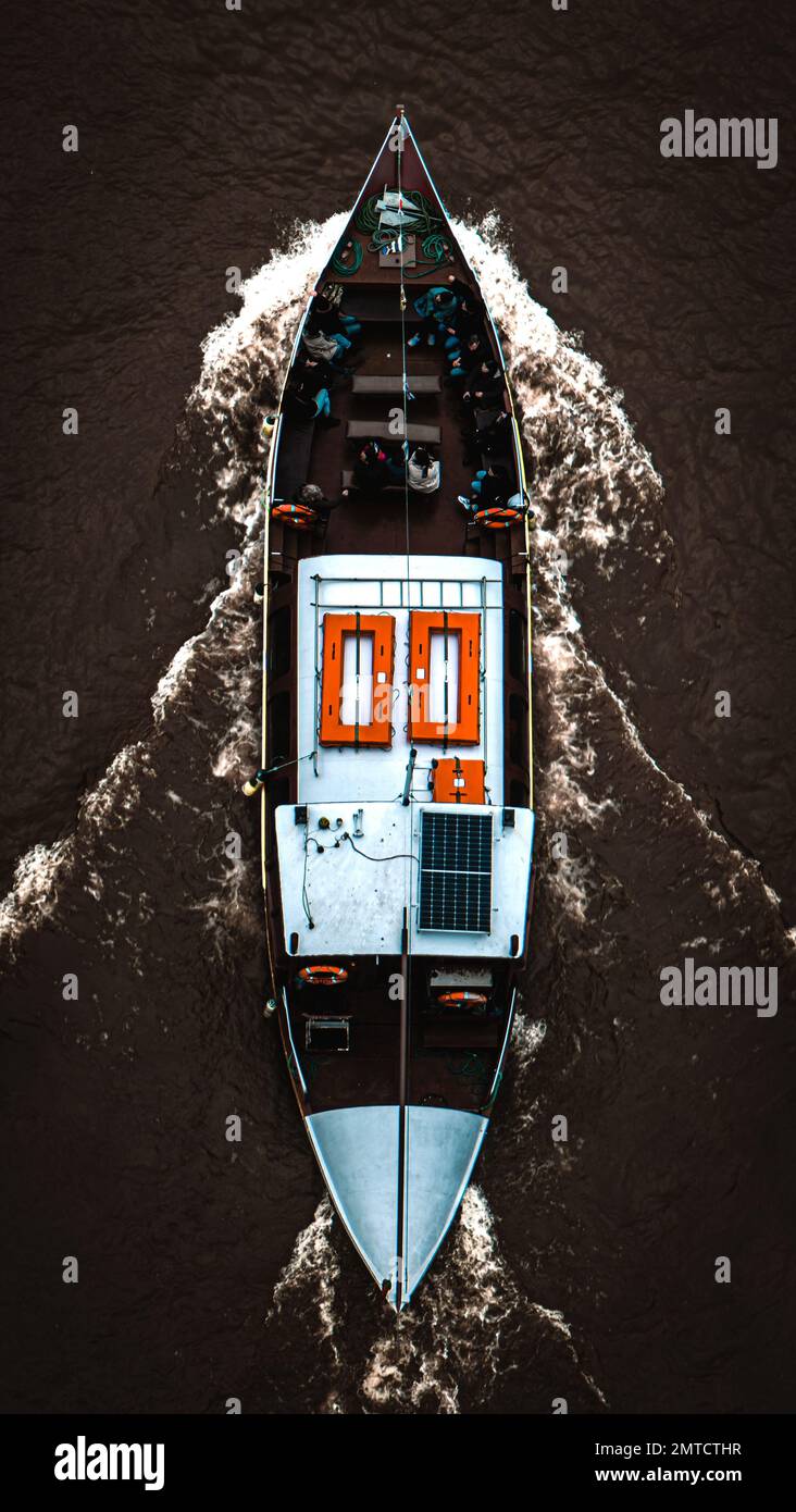 A top view of a boat with a group of tourists in touring in the dark ...