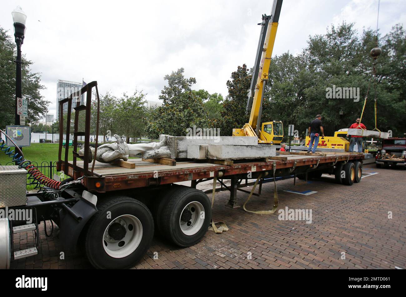 Workers remove and load sections of a Confederate statue called "Johnny ...