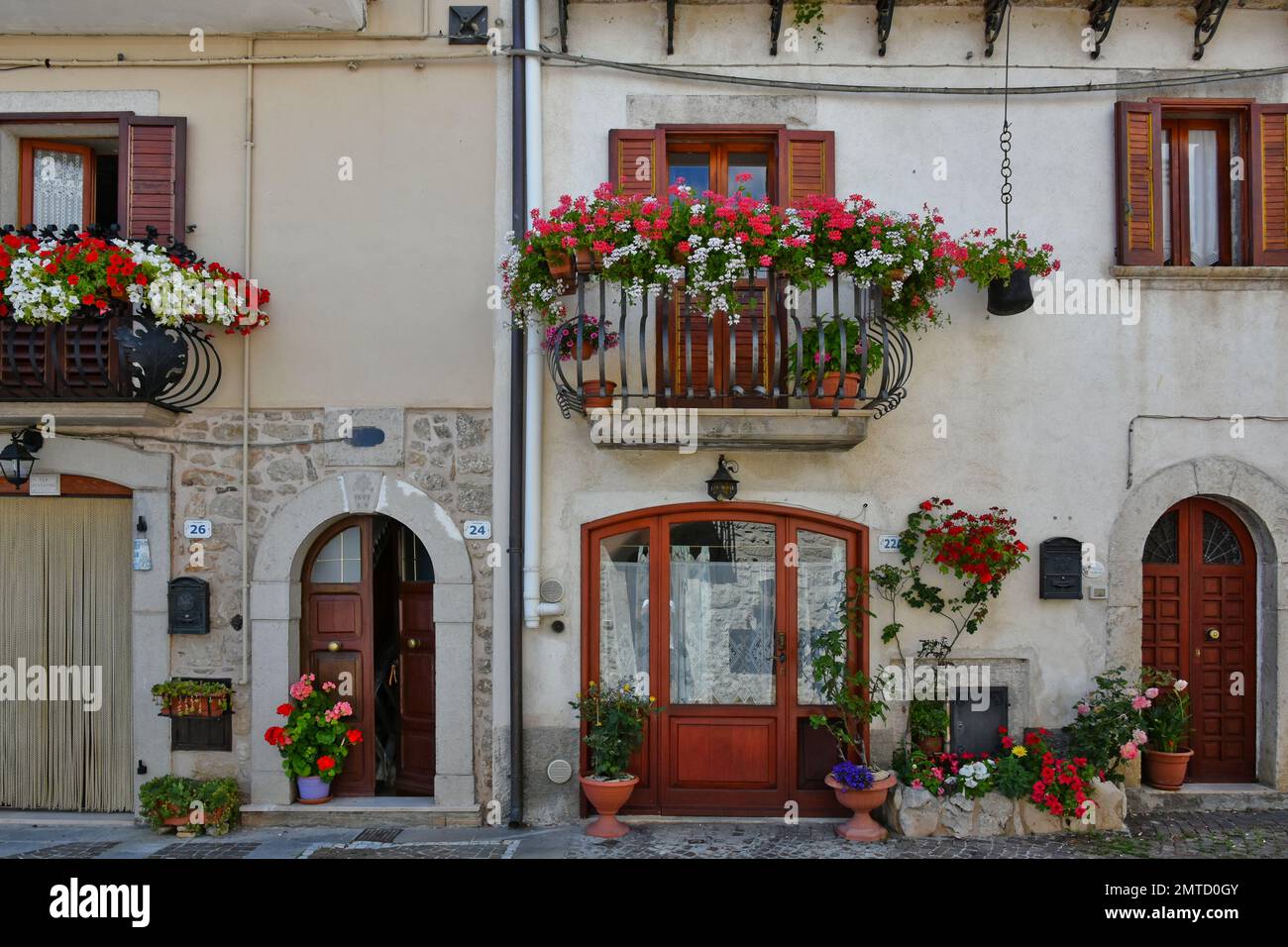 The facade of a stone house adorned with flowers in Scontrone Italy ...