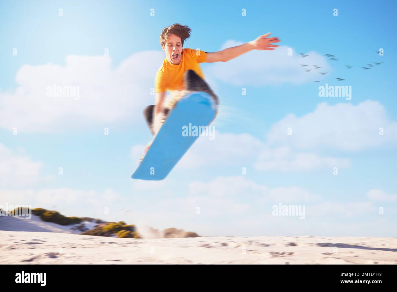 Sport, sandboard man jumping man in a desert for extreme sports ...