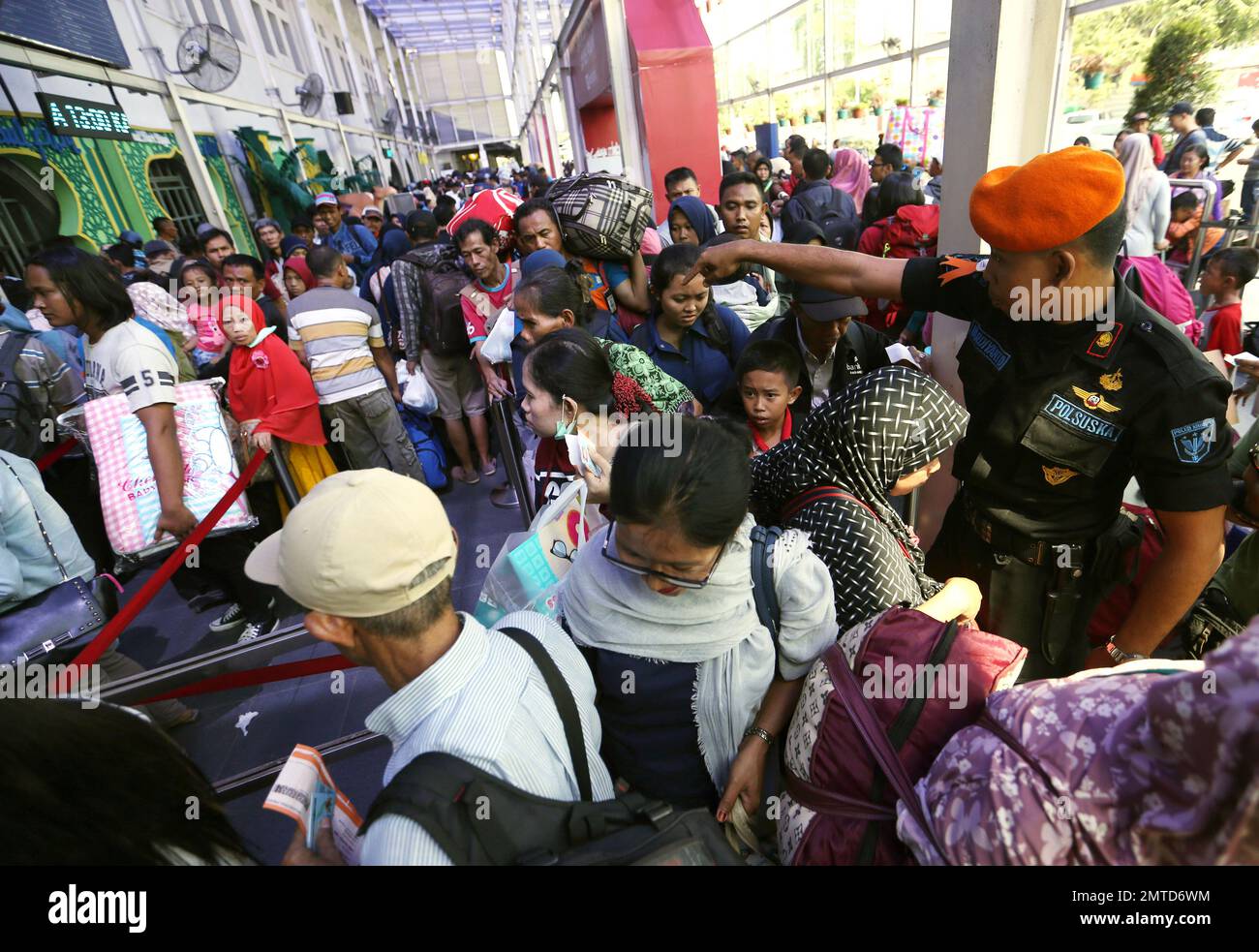 People scramble to enter Senen train station as they leave for their ...