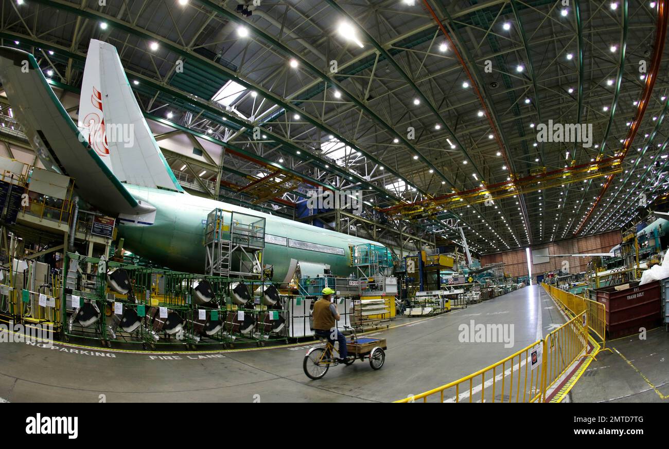 A worker rides a tricycle along Boeing Co.'s 777 assembly line, Monday ...