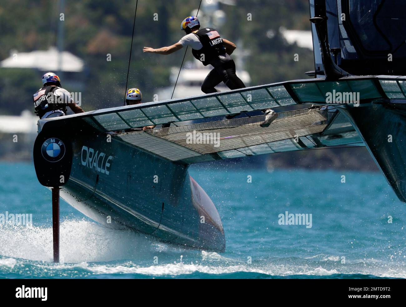 Oracle Team USA wing trimmer Kyle Langford, center, crosses the boat as ...