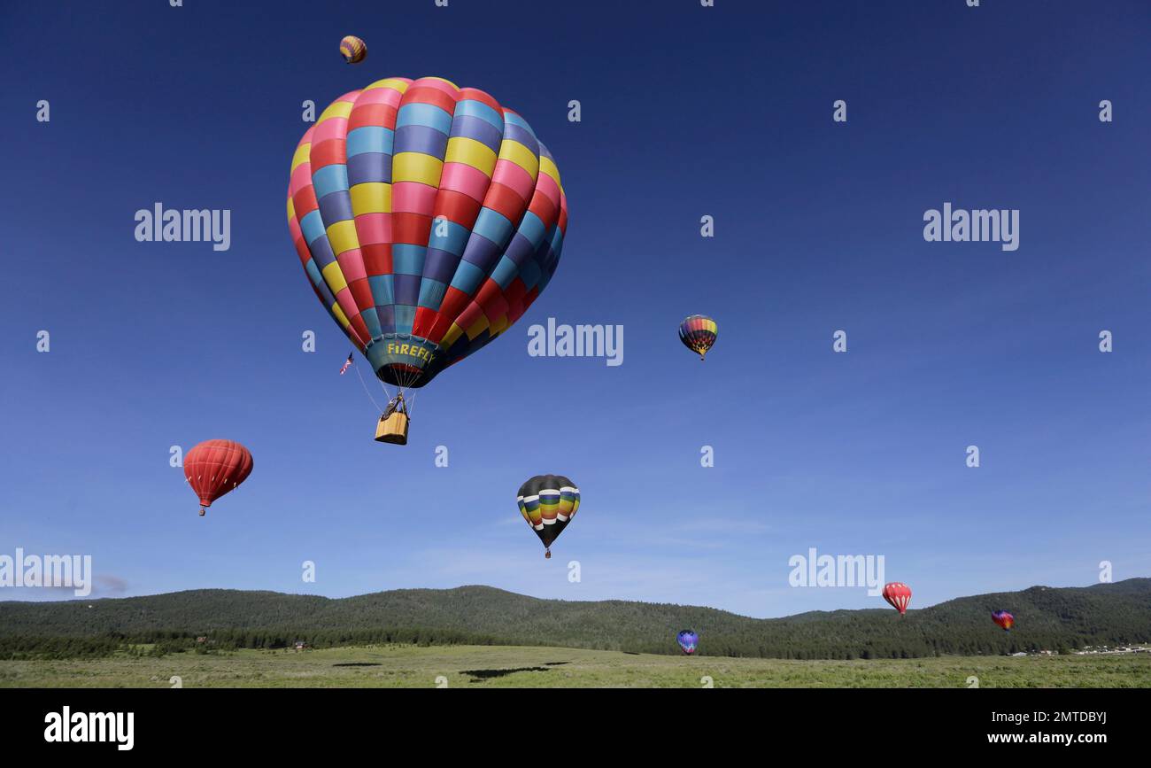 Balloons launch from a field at sunrise during the Balloons over Angel ...