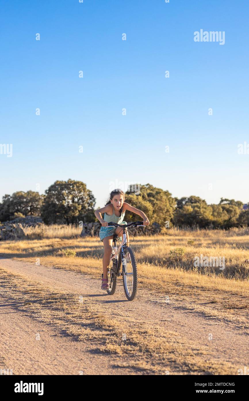 Teen girl riding with her bike on a countryside Stock Photo - Alamy