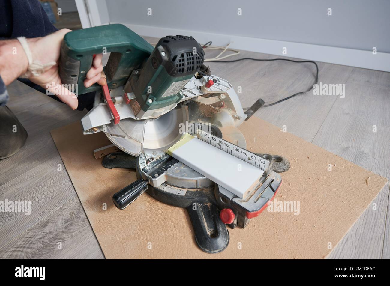 Close up of male worker using electric circular saw with abrasive disc ...
