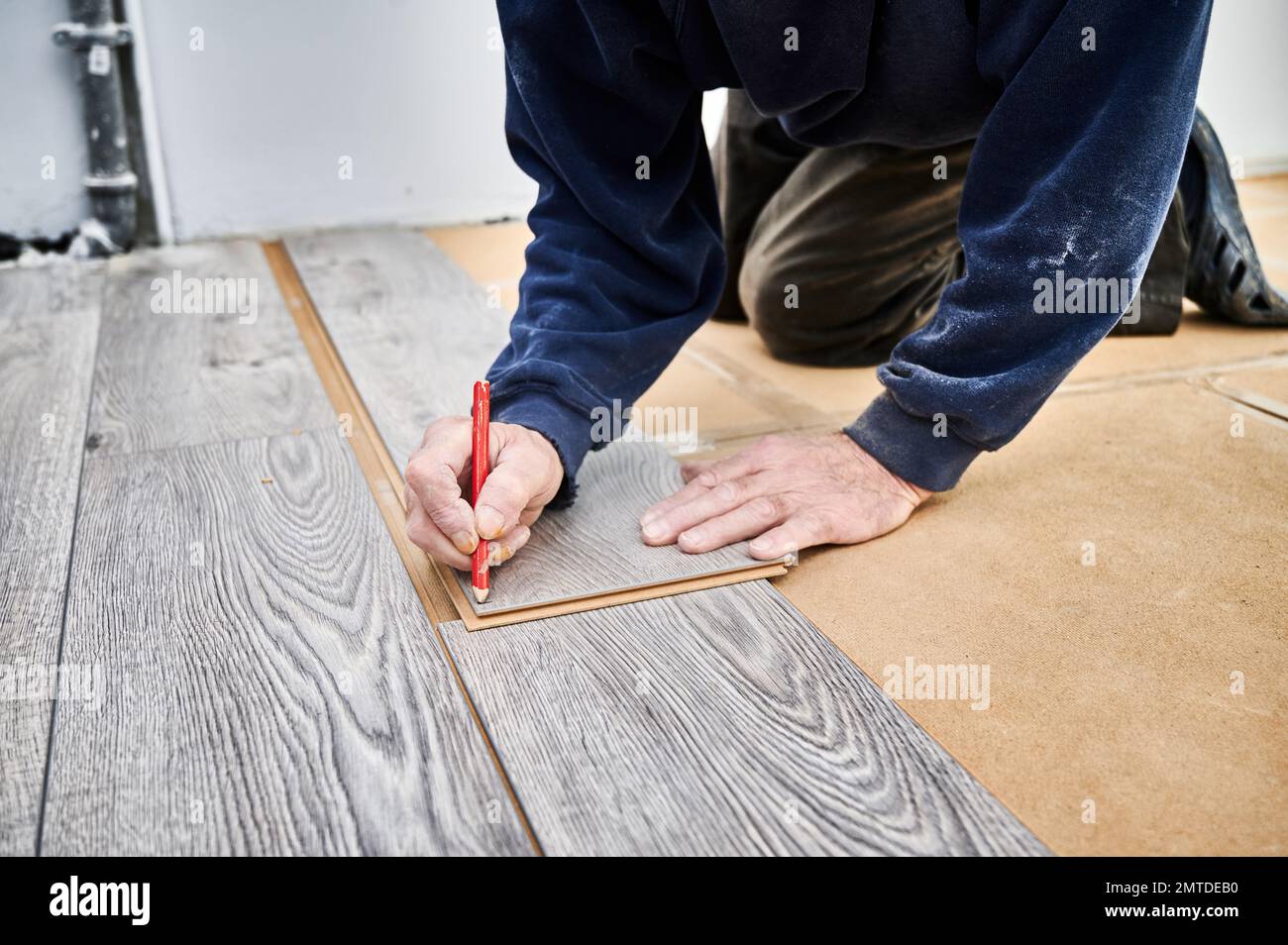 Close up of man construction worker with pencil in hand drawing mark on ...
