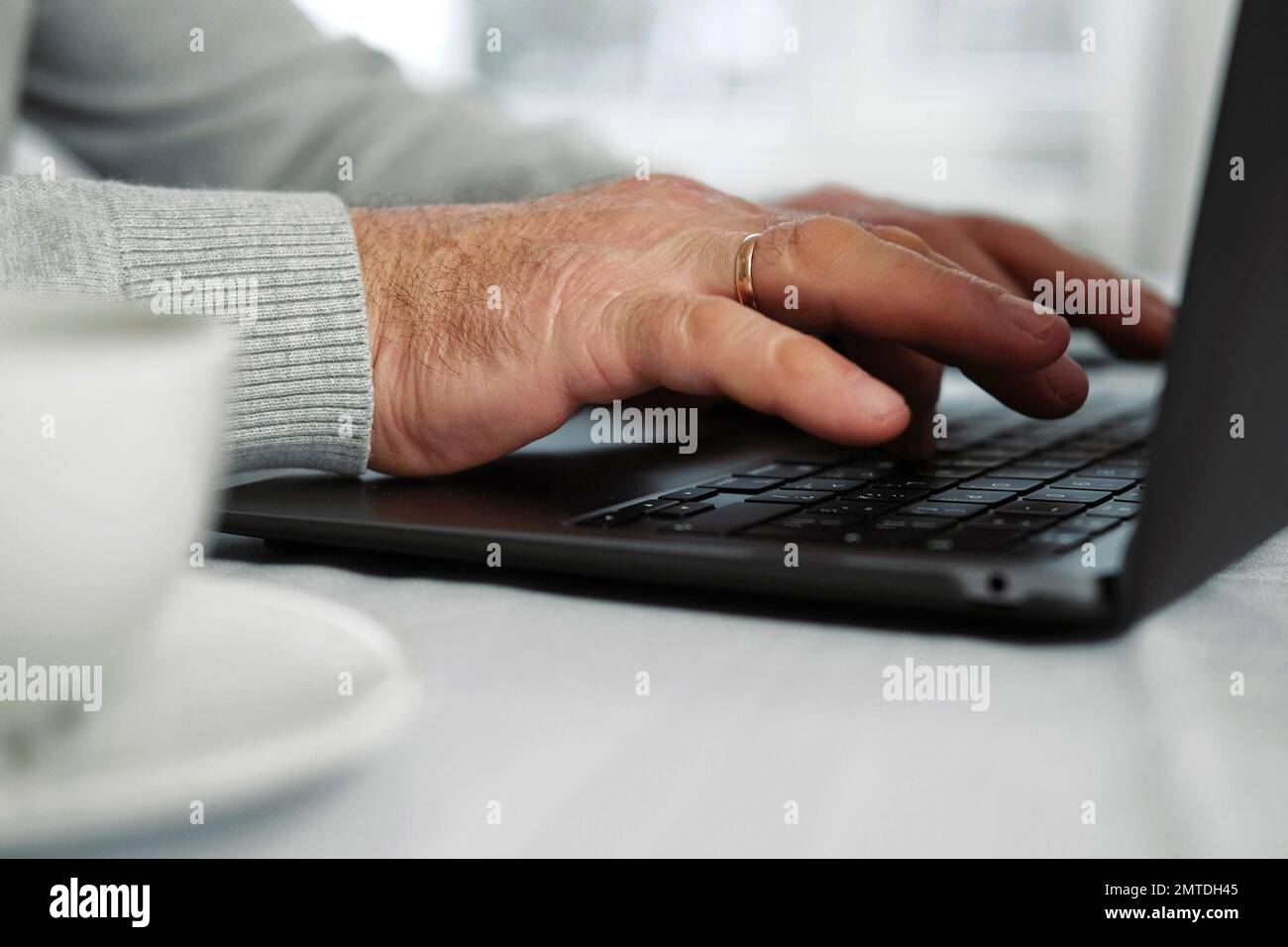 Closeup of senior man hands using laptop. Cropped side view of wrinkled ...