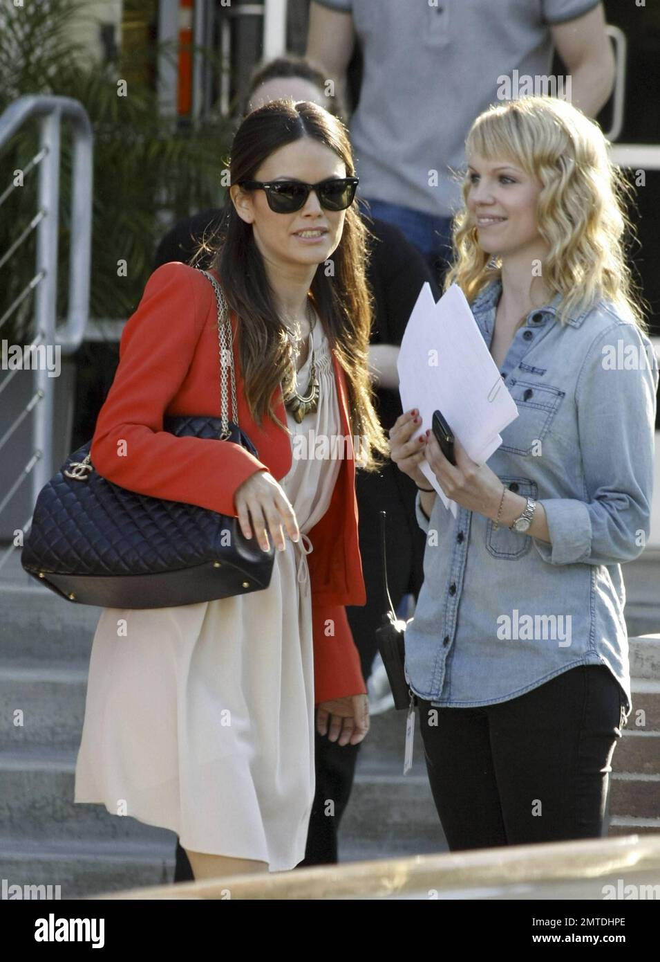 Wearing a red jacket and a simple white dress, actress Rachel Bilson ...