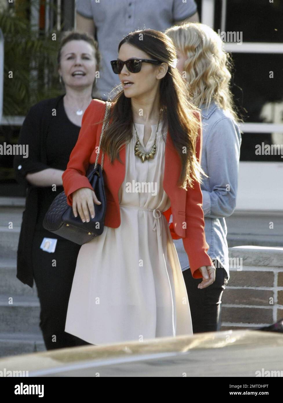Wearing a red jacket and a simple white dress, actress Rachel Bilson ...