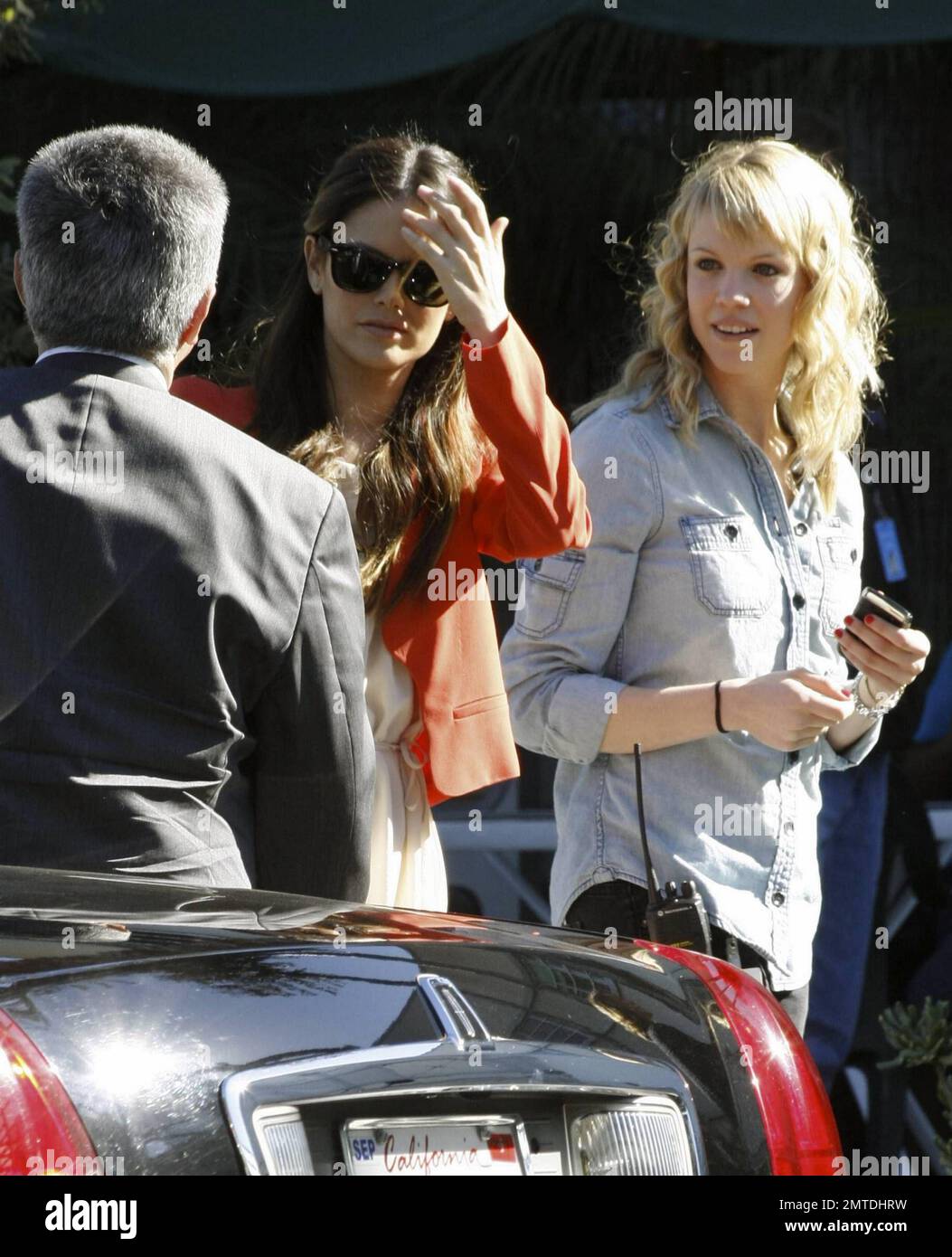 Wearing a red jacket and a simple white dress, actress Rachel Bilson ...