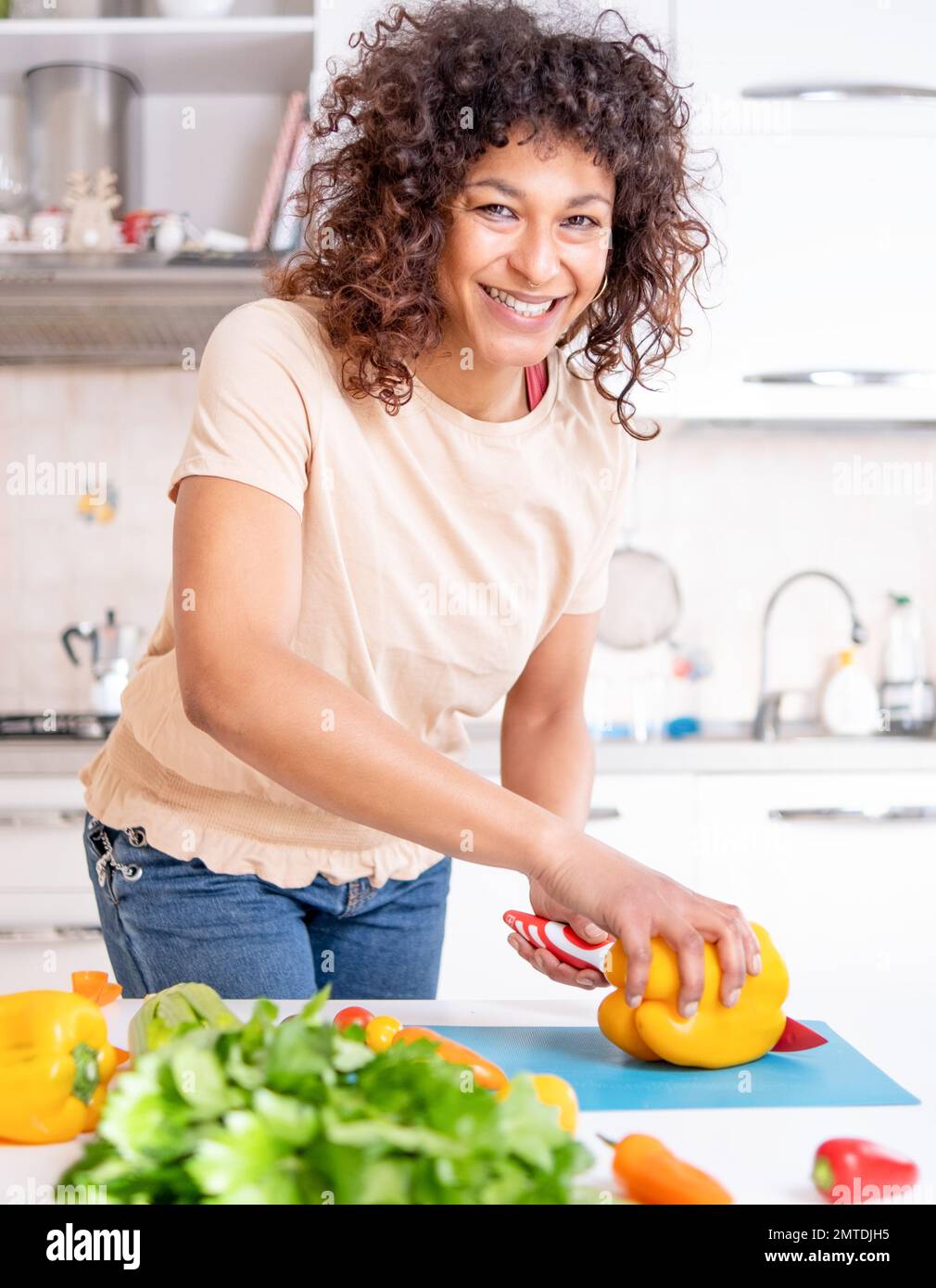 Cheerful black woman cooking at home looking a the camera Stock Photo ... Cheerful black woman cooking at home looking a the camera Stock Photo ...