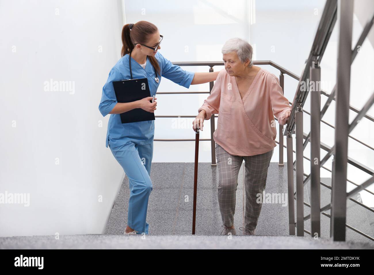 Doctor helping senior patient in modern hospital Stock Photo - Alamy