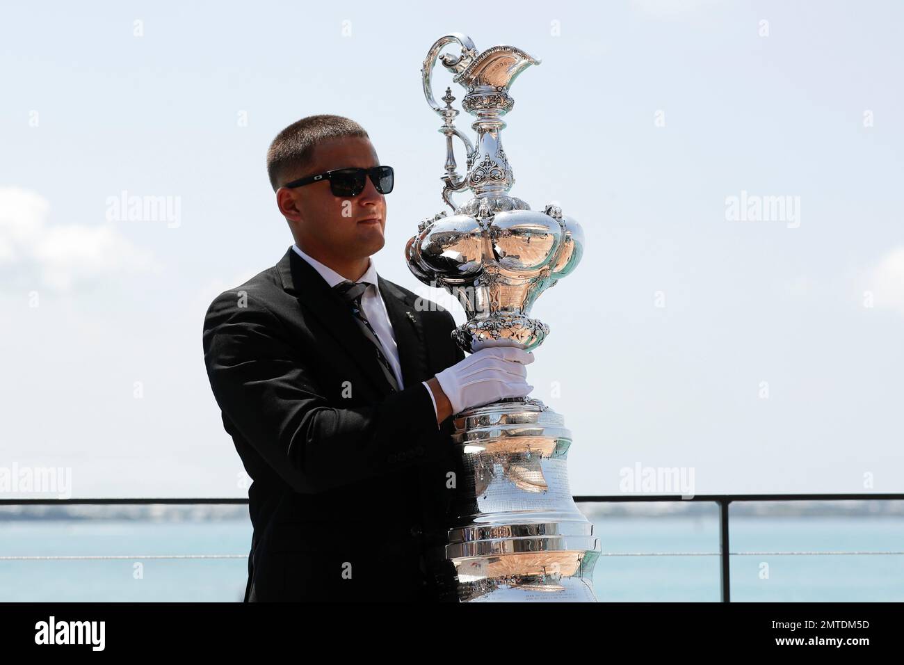 An attendant carries the America's Cup trophy, known as the "Auld Mug ...