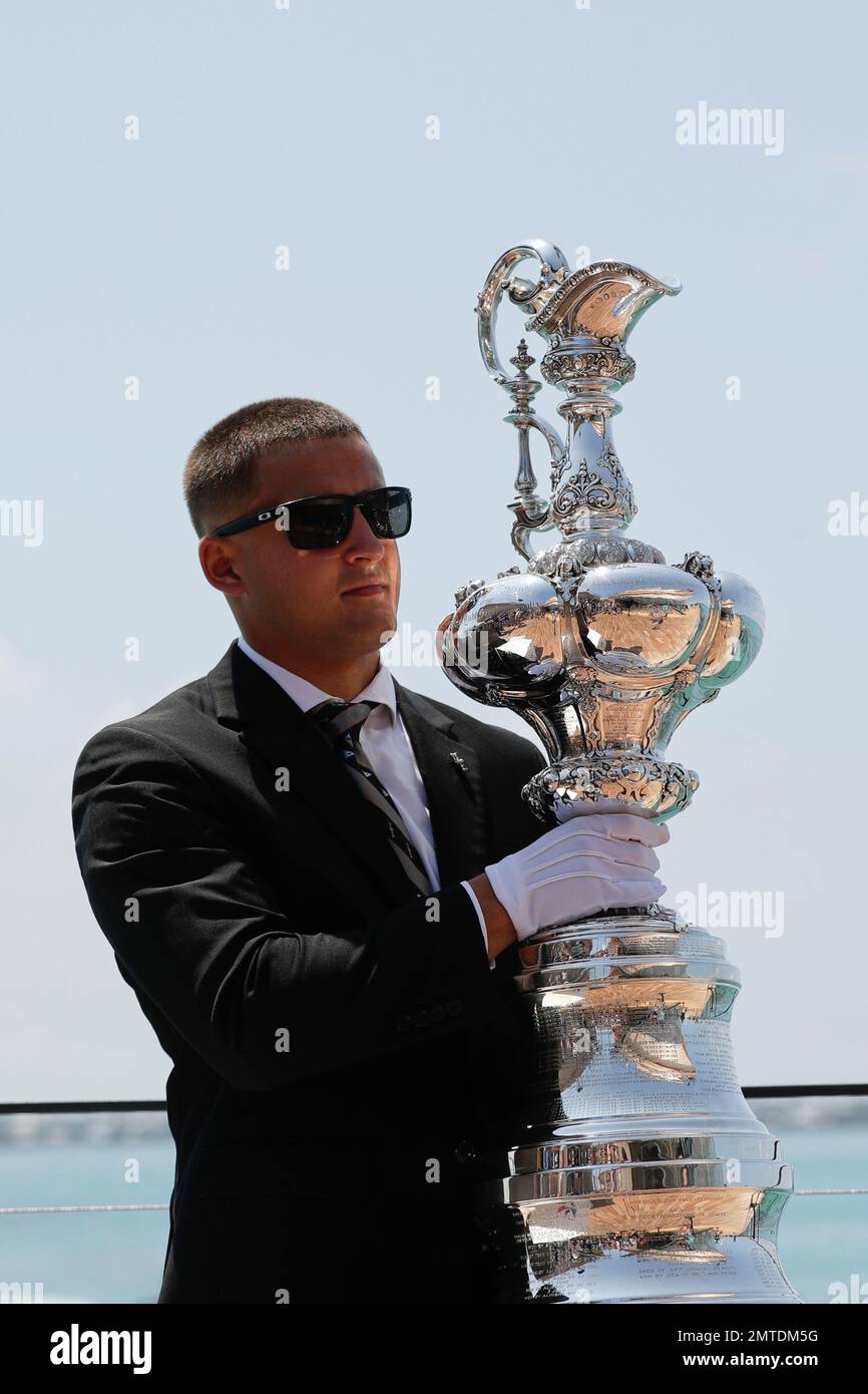An attendant carries the America's Cup trophy, known as the "Auld Mug ...