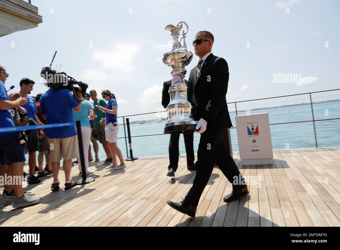 An attendant carries the America's Cup trophy, known as the "Auld Mug ...
