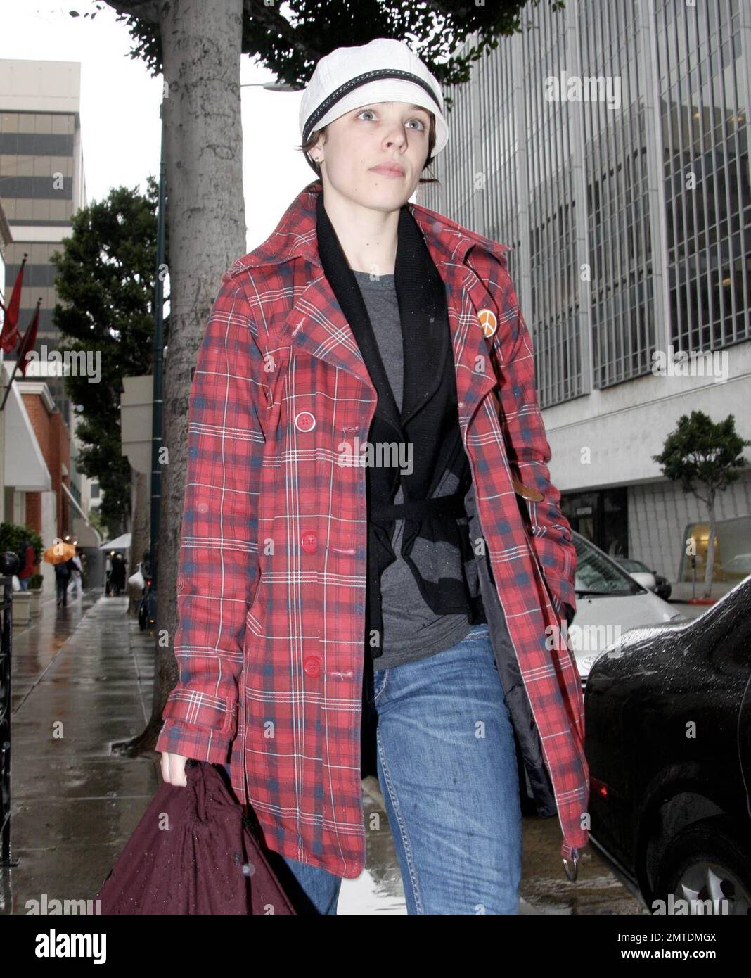 Rachel McAdams and a mystery man try to dodge rain drops and ...