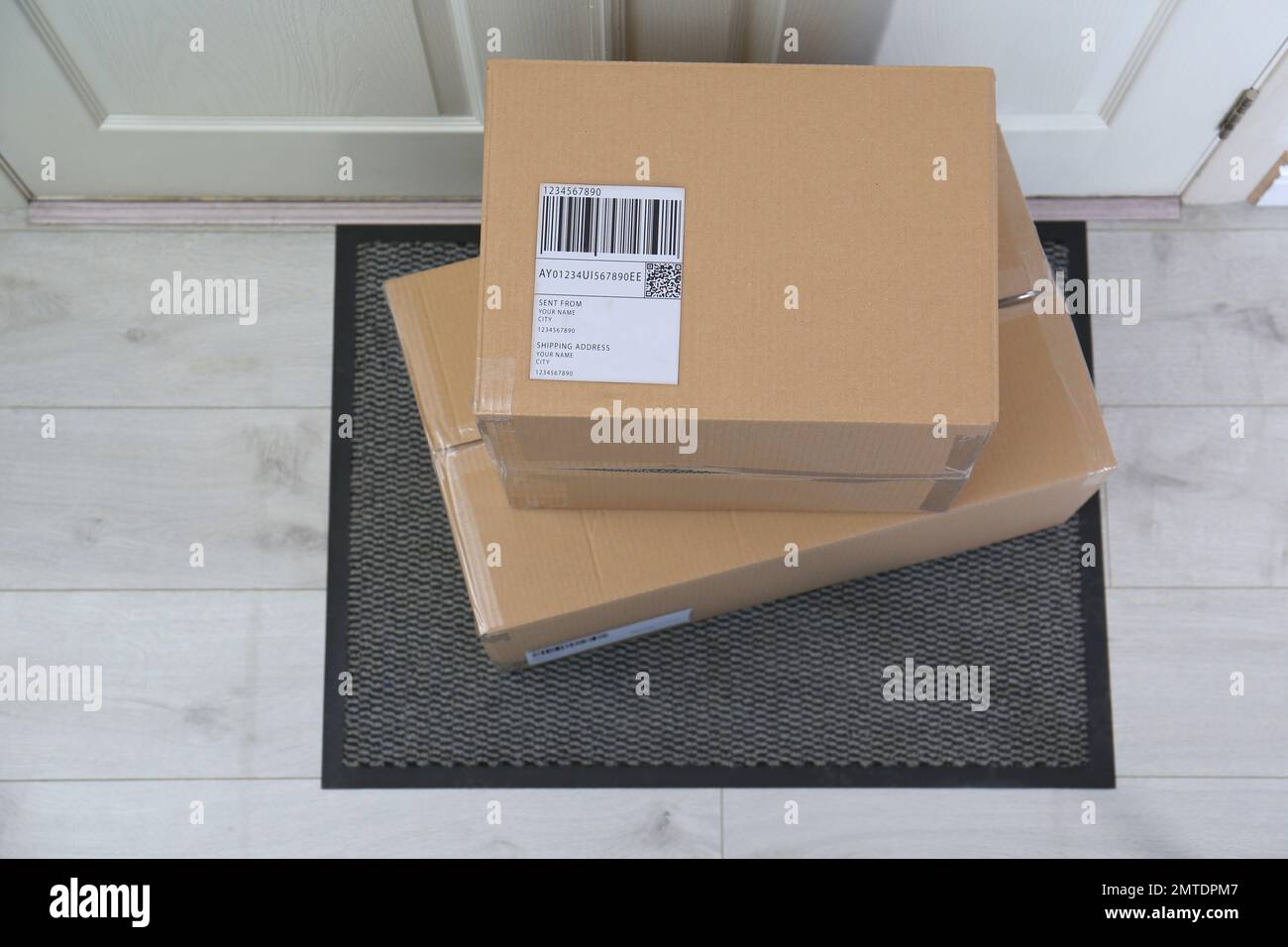 Cardboard boxes on rug near door, top view. Parcel delivery service ...