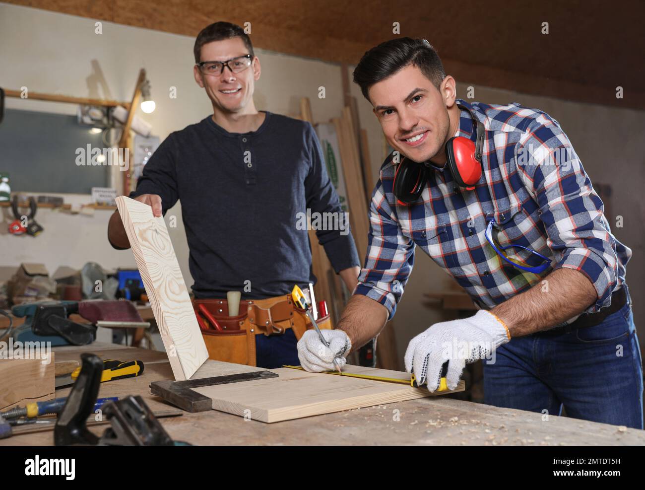 Professional carpenters working with wooden boards in workshop Stock ...