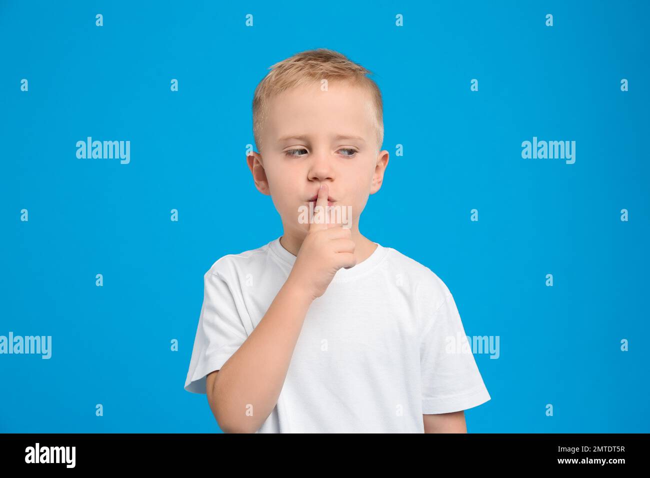 Portrait of cute little boy on light blue background Stock Photo - Alamy