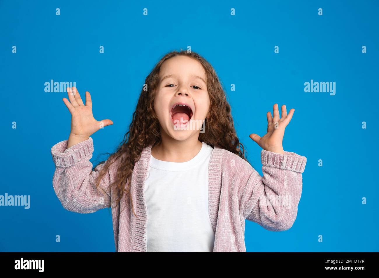 Portrait of cute little girl on light blue background Stock Photo - Alamy