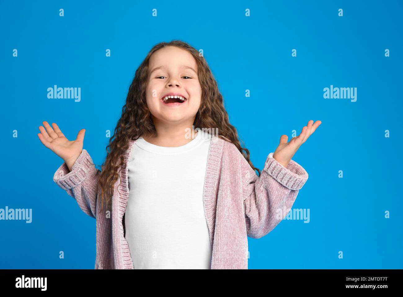 Portrait of cute little girl on light blue background Stock Photo - Alamy
