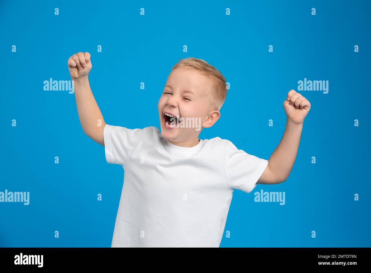Portrait of cute little boy on light blue background Stock Photo - Alamy