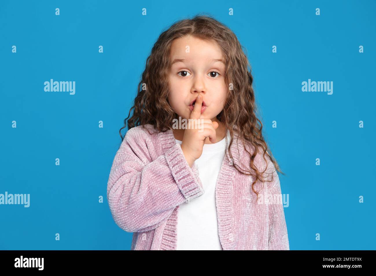 Portrait of cute little girl on light blue background Stock Photo - Alamy