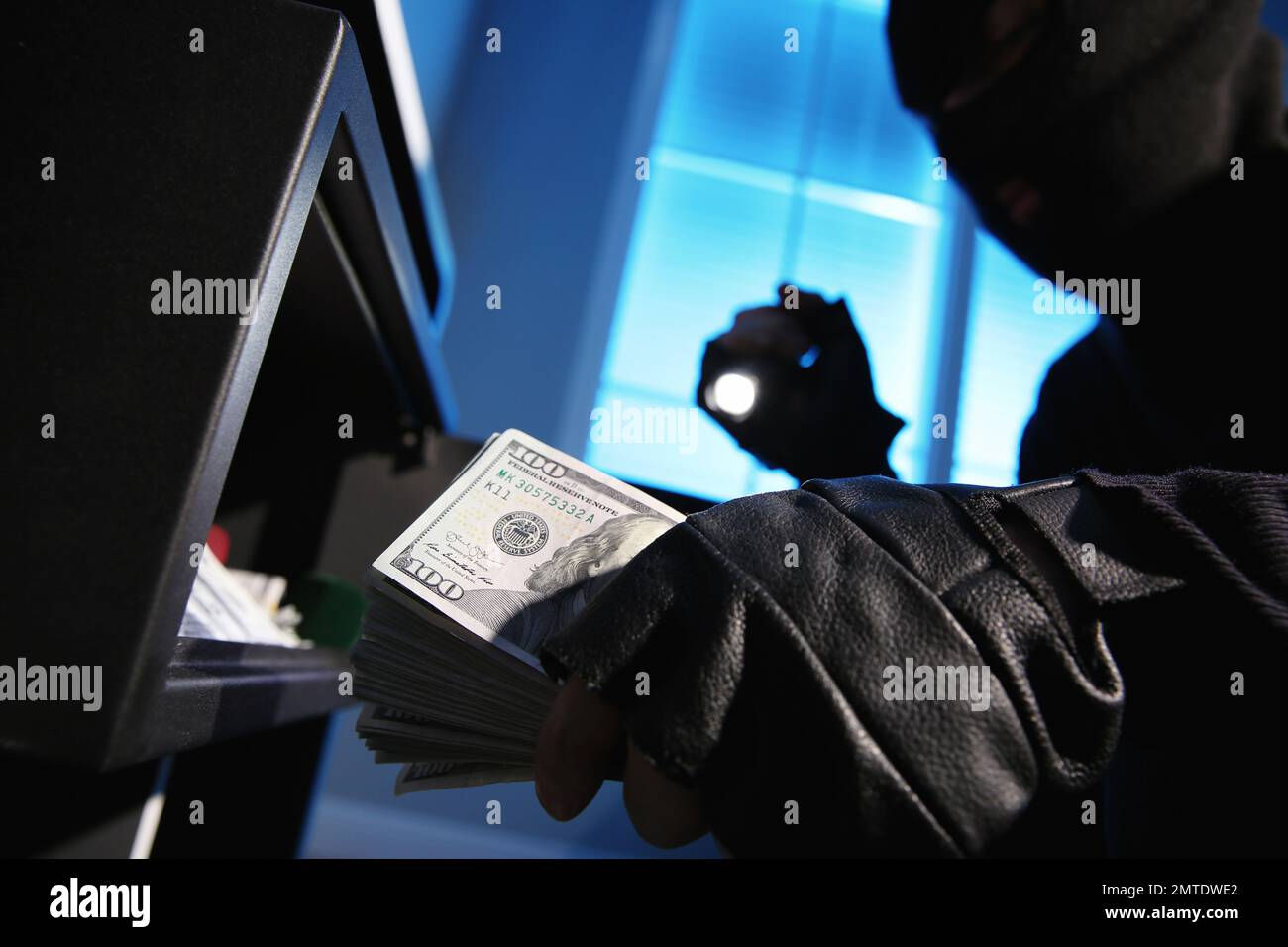 Thief taking money out of steel safe indoors at night, closeup Stock ...