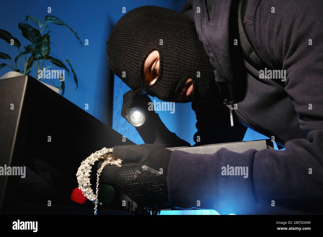 Thief taking jewelry out of steel safe indoors at night Stock Photo - Alamy