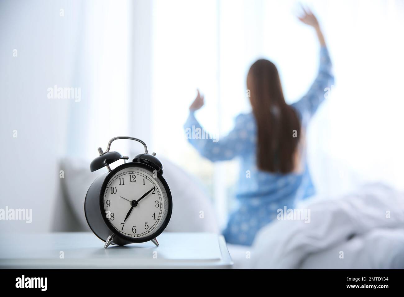 Girl stretching on bed alarm clock hi-res stock photography and images ...