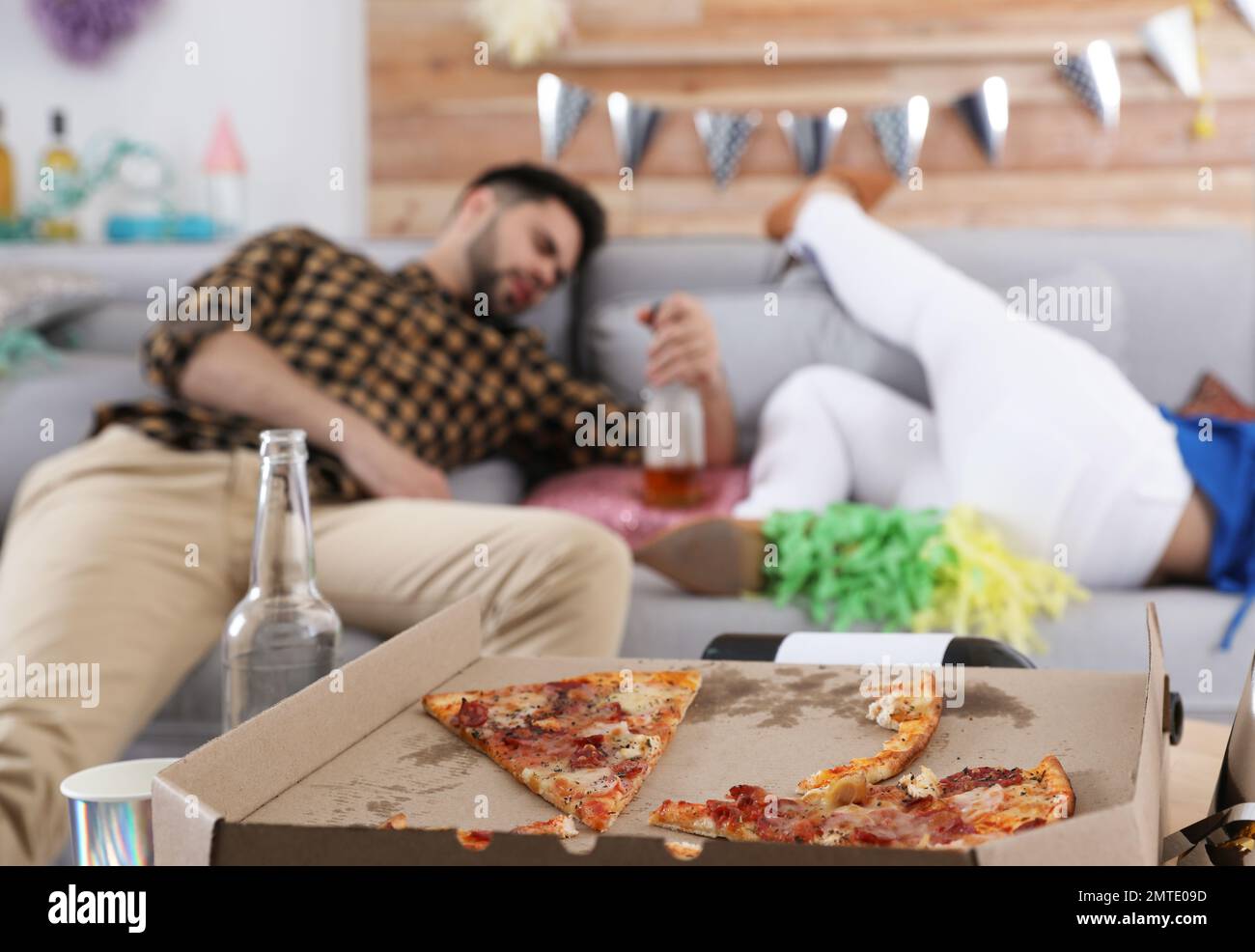Drunk friends sleeping in messy room after party, focus on pizza Stock ...