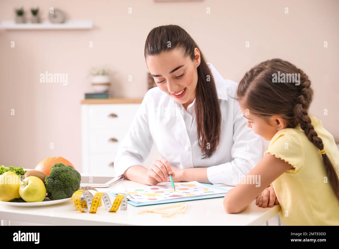 Little girl visiting professional nutritionist in office Stock Photo ...