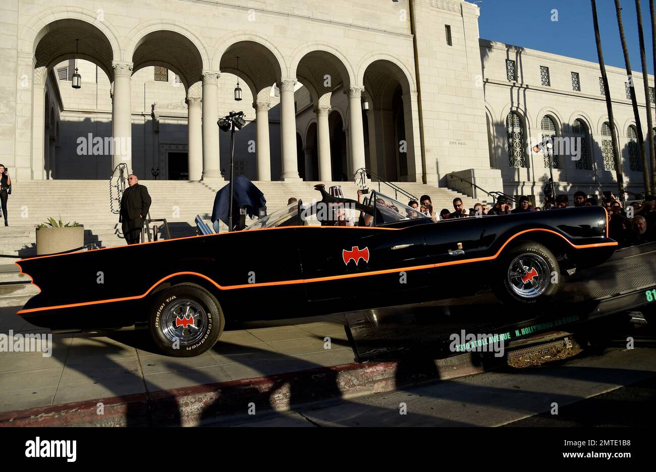 A Batmobile gets loaded onto the sidewalk before a tribute to "Batman ...
